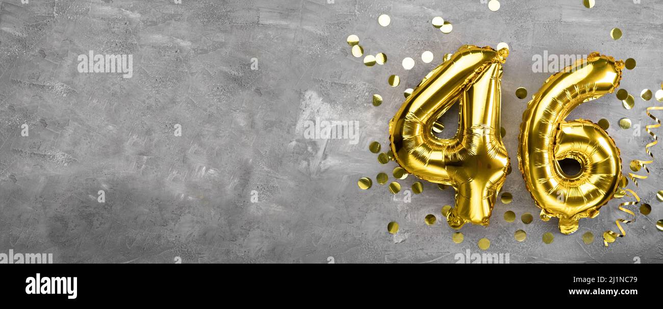Yellow foil balloon number, number forty six concrete background ...