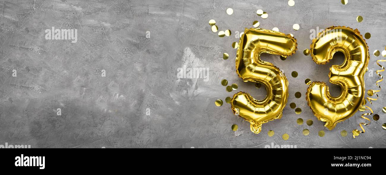 Yellow foil balloon number, number fifty three concrete background ...