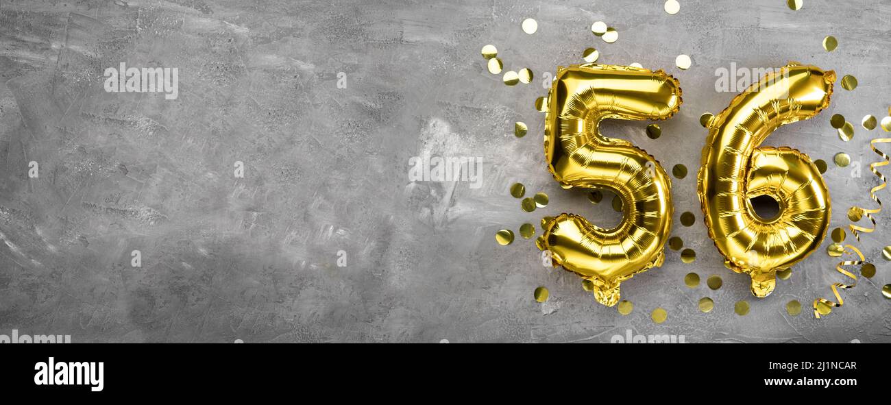 Yellow foil balloon number, number fifty six concrete background ...