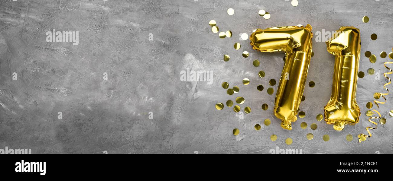 Yellow foil balloon number, number seventy one on a concrete background ...
