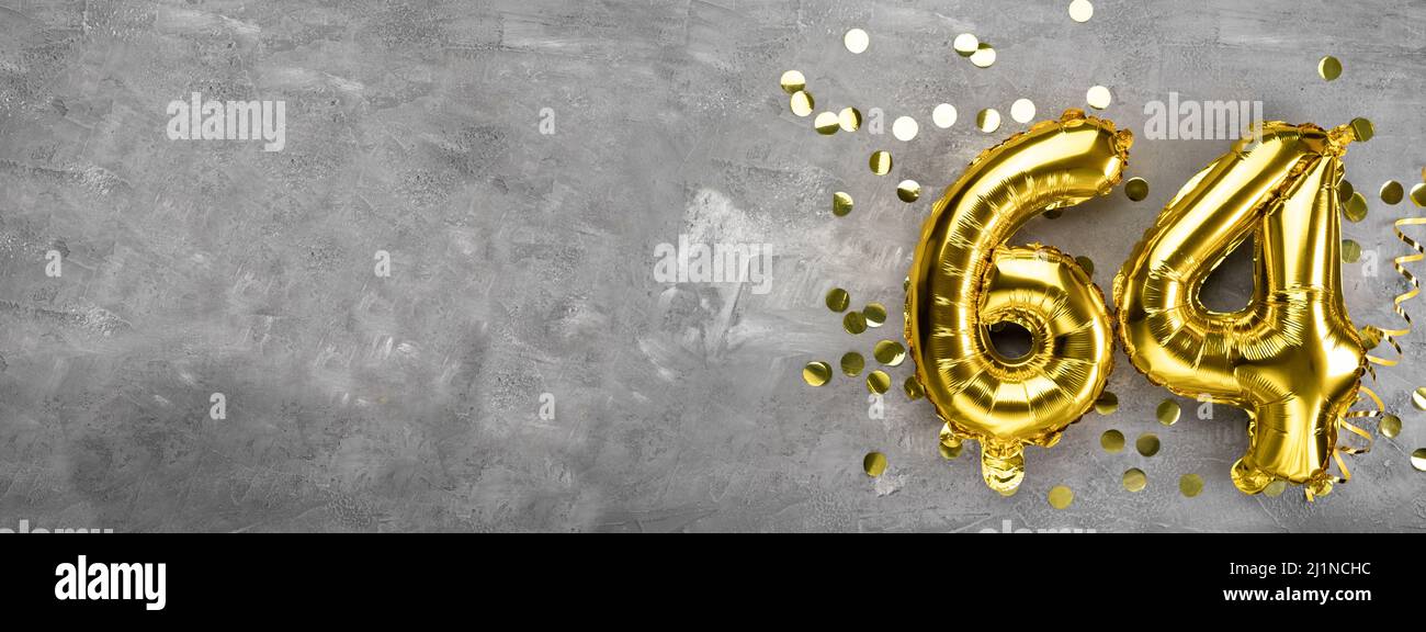 Yellow foil balloon number, number sixty four on a concrete background ...
