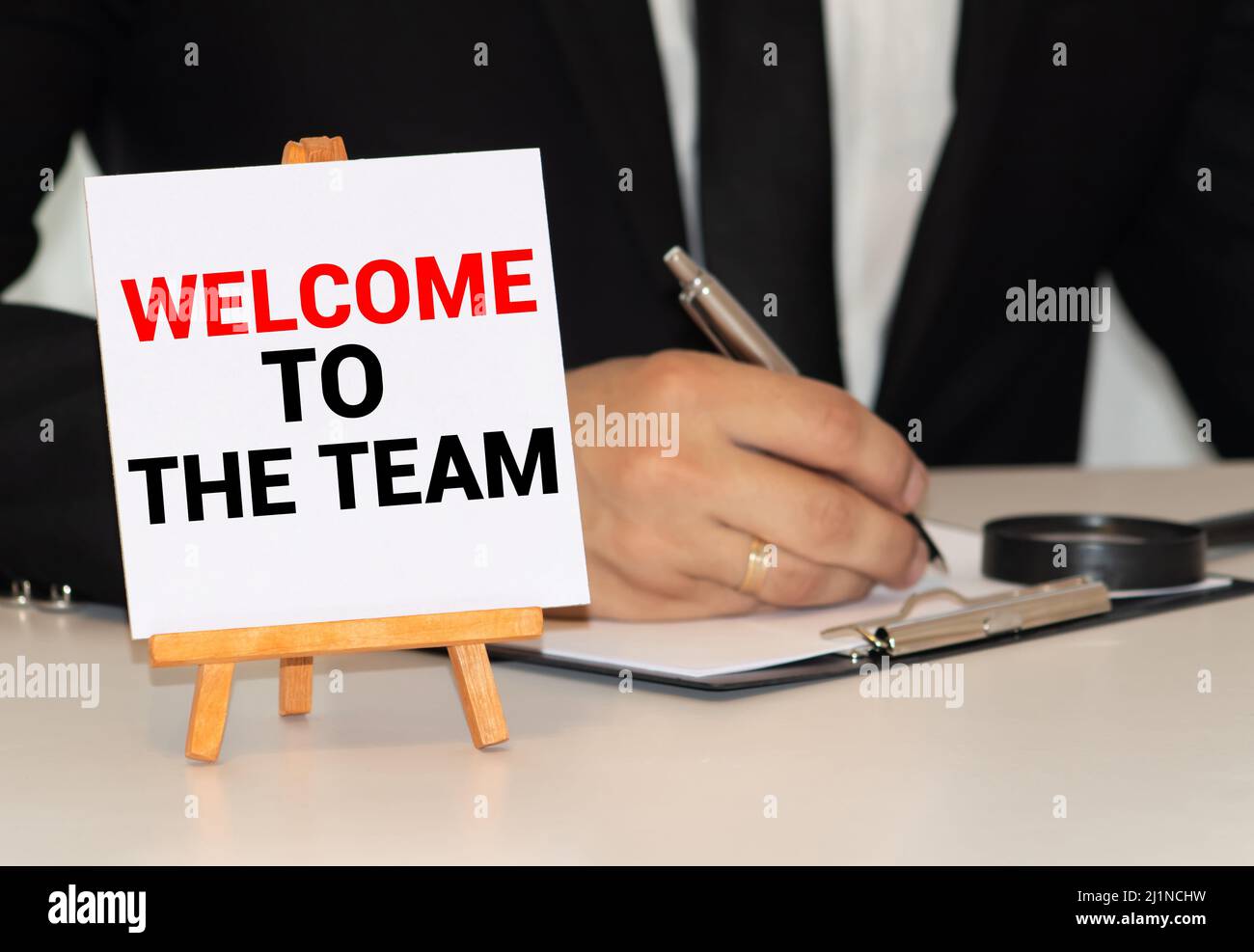 Businesspeople holding whiteboard with 'welcome to the team' text ...
