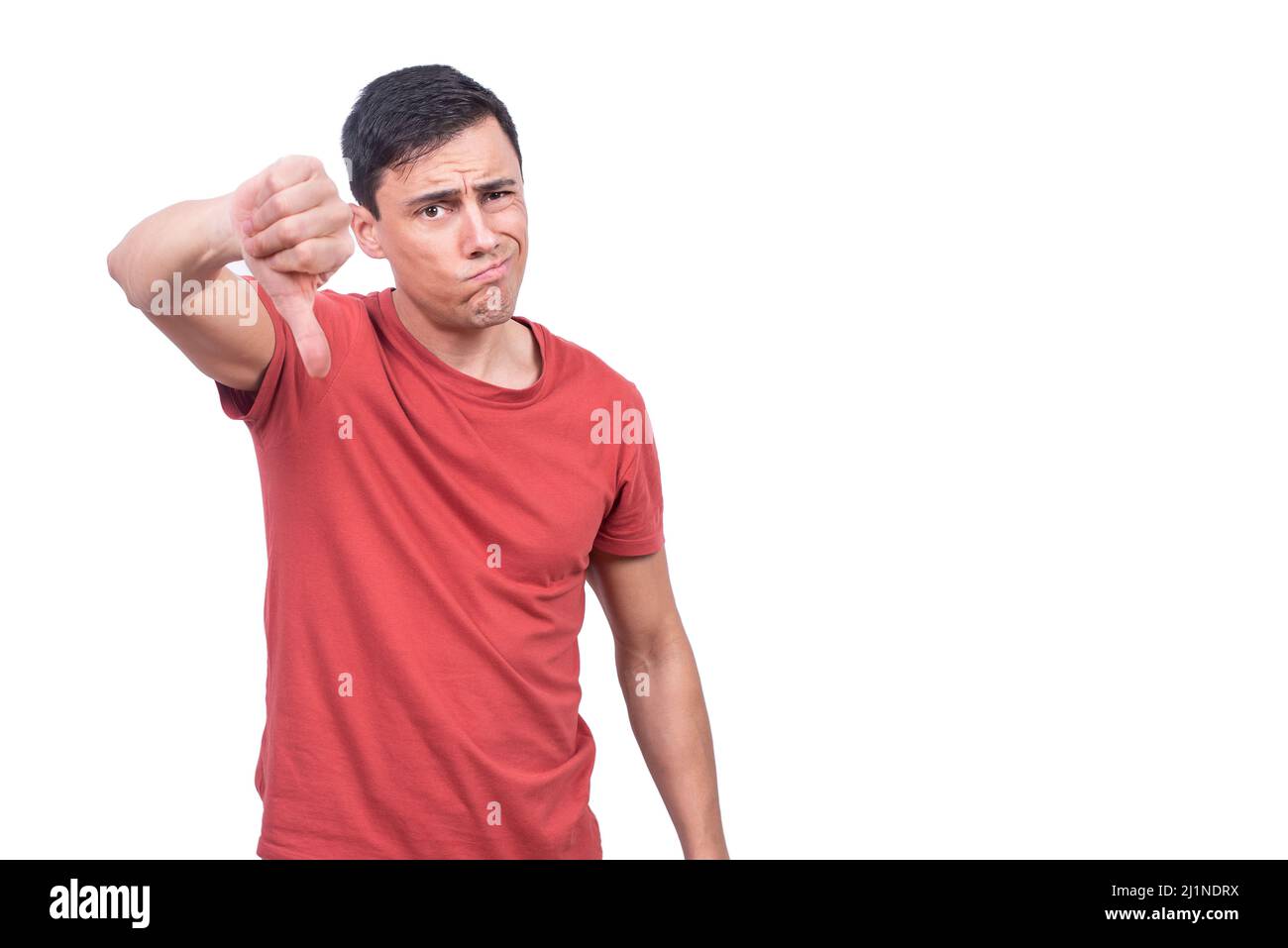 Sceptic guy giving thumb down gesture in studio Stock Photo - Alamy