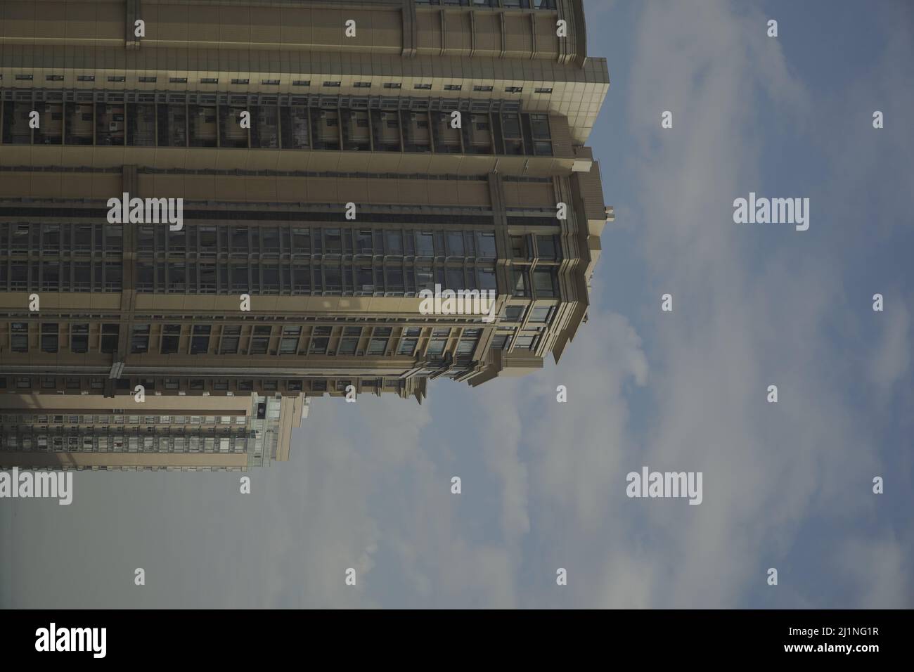 A tall residential building against the blue sky in Macau, China Stock ...