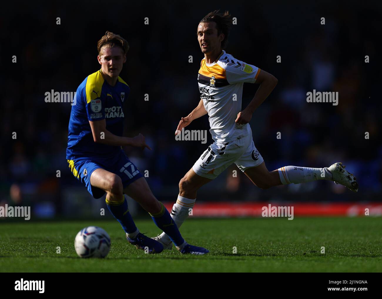 Cambridge United's Harrison Dunk (right) takes on AFC Wimbledon's Jack ...