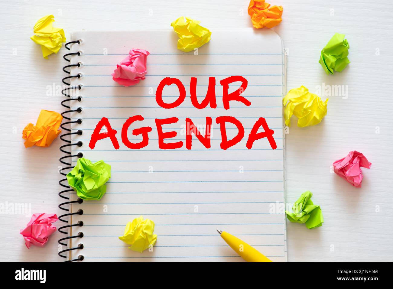 Notebook writing Our Agenda, Office table with laptop ,coffee cup ...