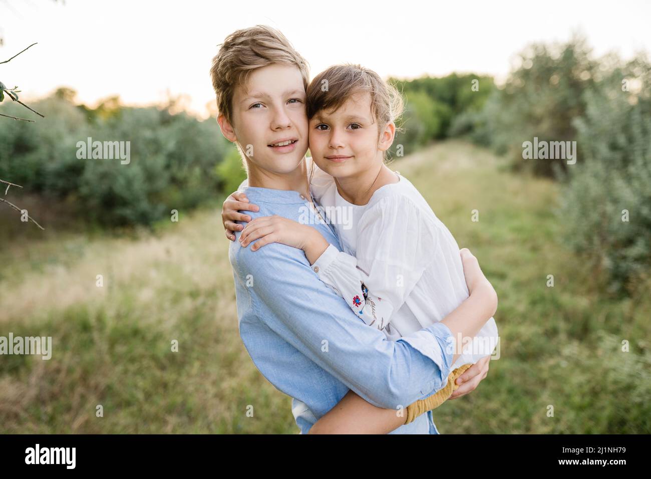 Portrait of older brother and younger sister together outside Stock ...