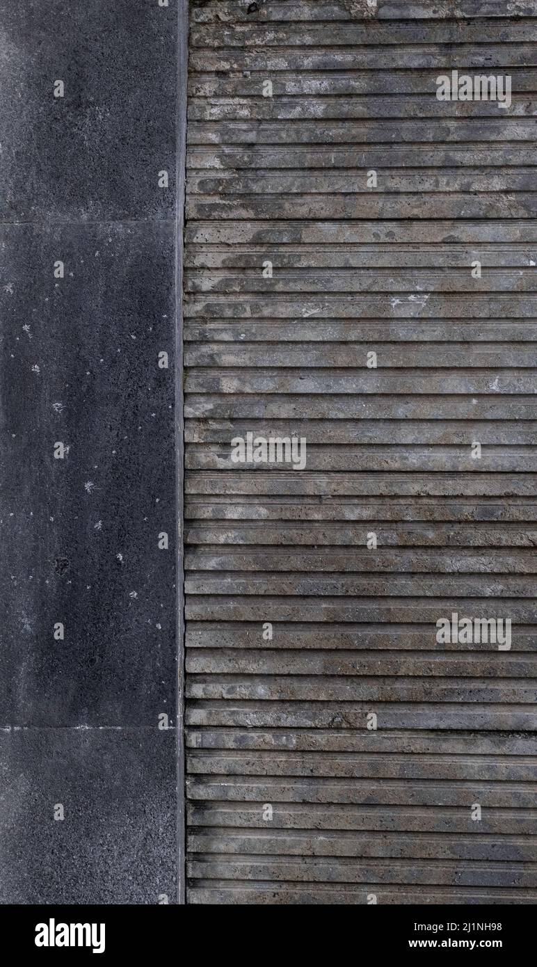 Gray 3 dimensional concrete shutter panel against deep blue old cement ...