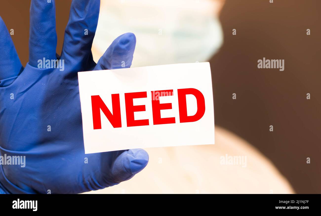 Hand holding card with red word of Need Stock Photo - Alamy