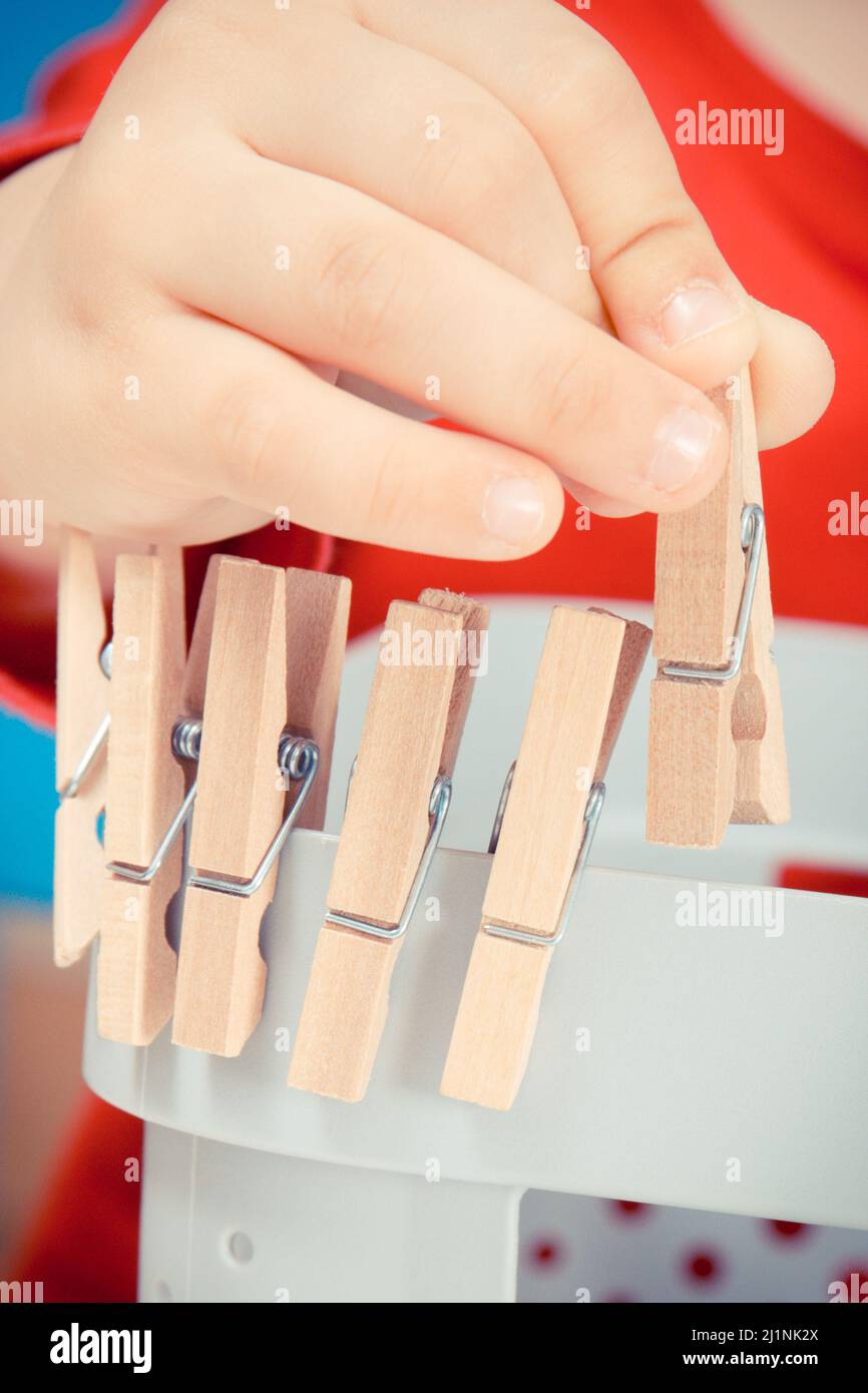 Little boy putting wooden clip on plastic box. Best creative game for ...