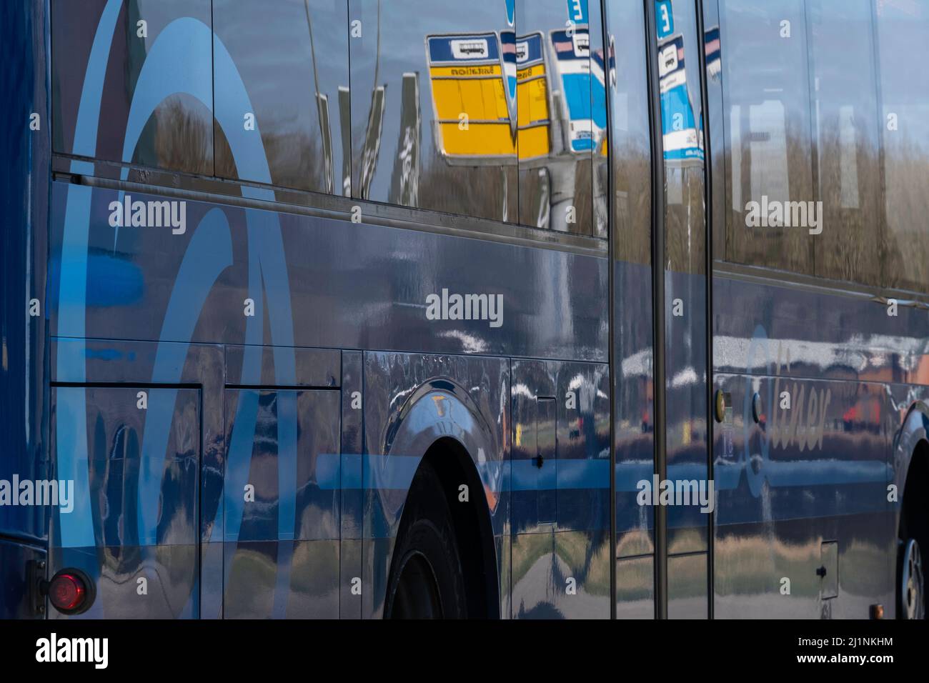 Reflections of signs in the shiny metal and glass of a blue Qliner ...