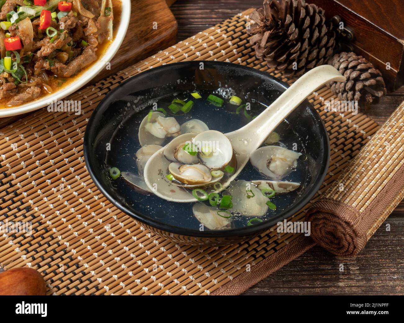 Clam Soup water in a dish isolated on mat side view on dark wooden ...