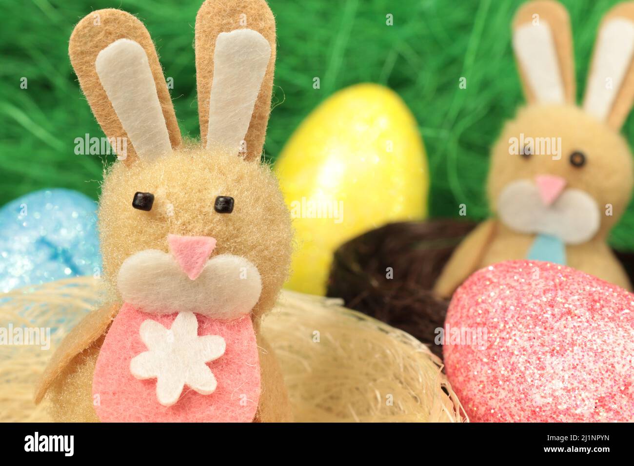 Two easter bunnies in cute nests surrounded by colorful easter eggs ...