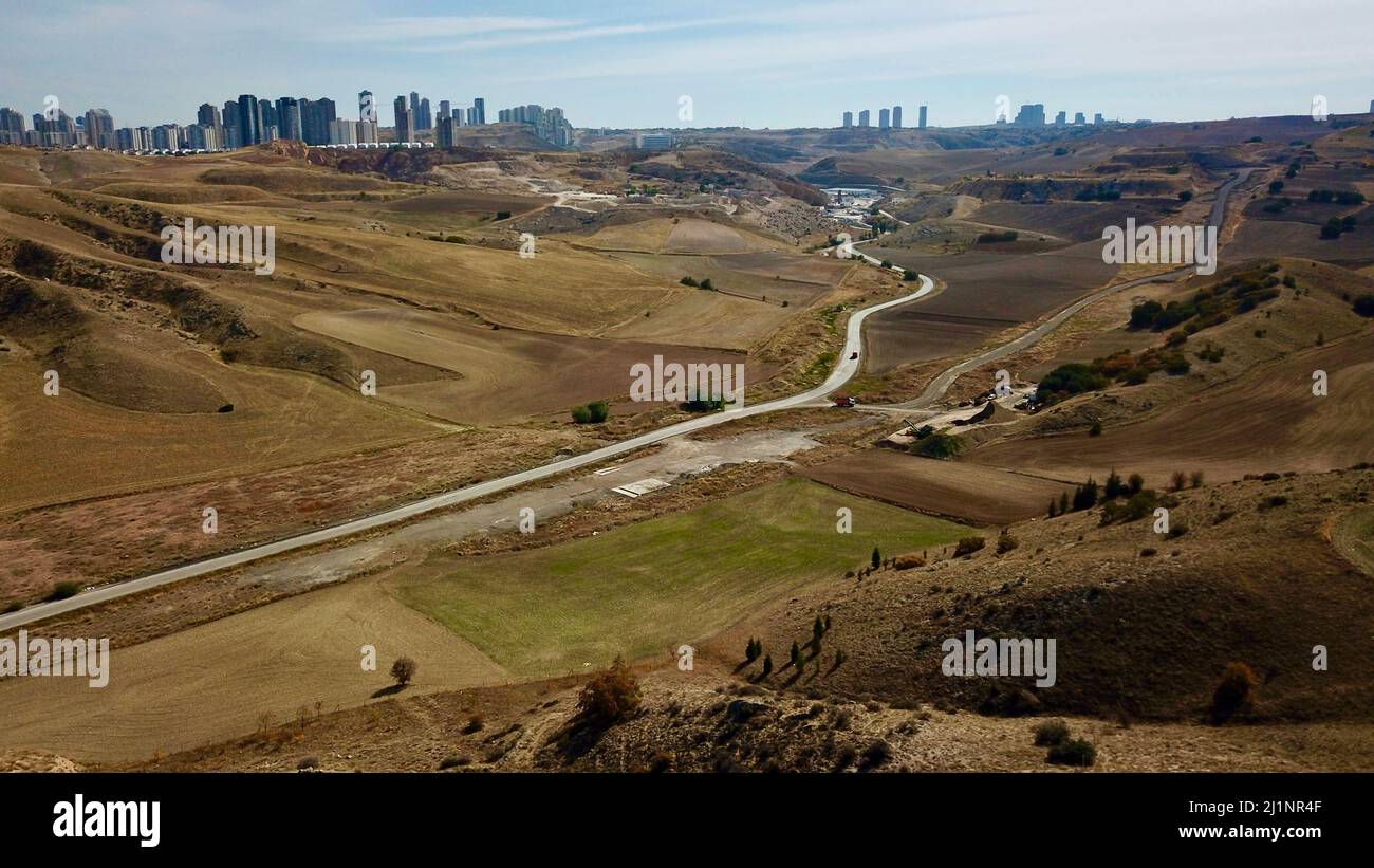 Rural settlement and land. Empty farmland and cityscape in the distance ...