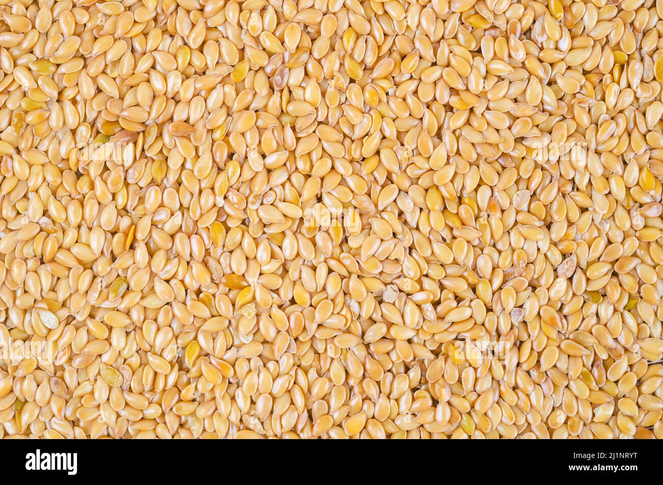 The Gold flax seeds texture as background Stock Photo - Alamy