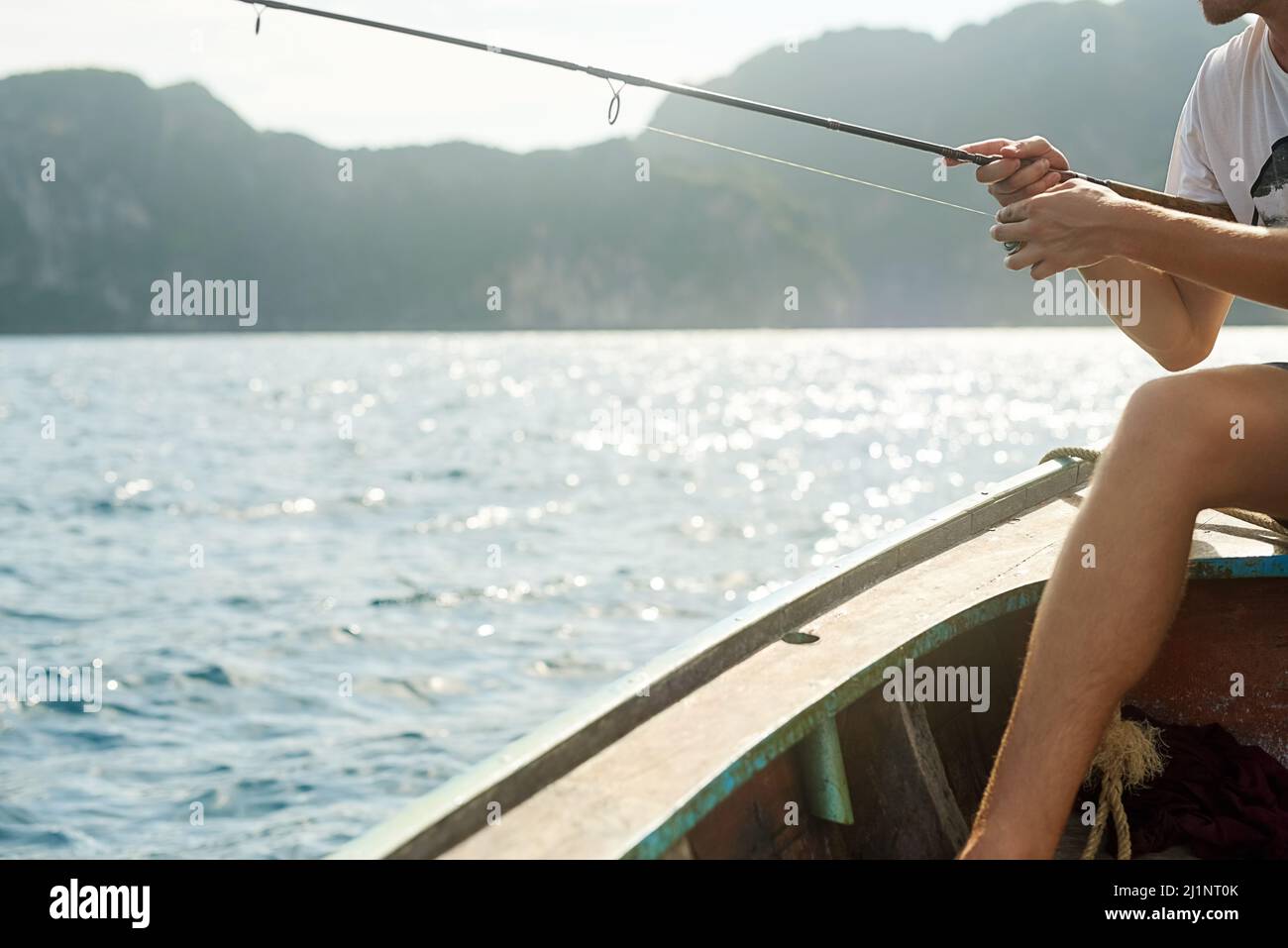 Casting his line. Cropped shot of an unrecognizable young man fishing ...