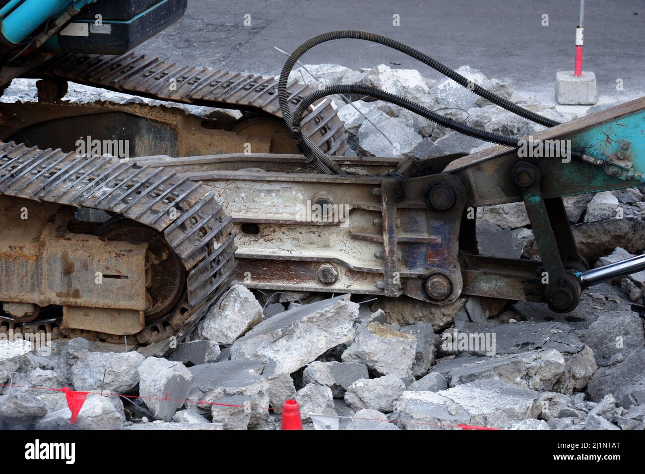 Rock excavator working to demolish concrete Stock Photo - Alamy