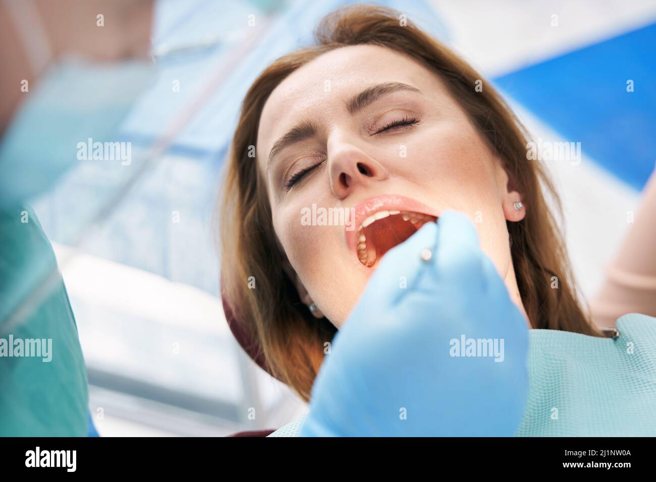 Dentist examining woman teeth in stomatology clinic Stock Photo - Alamy