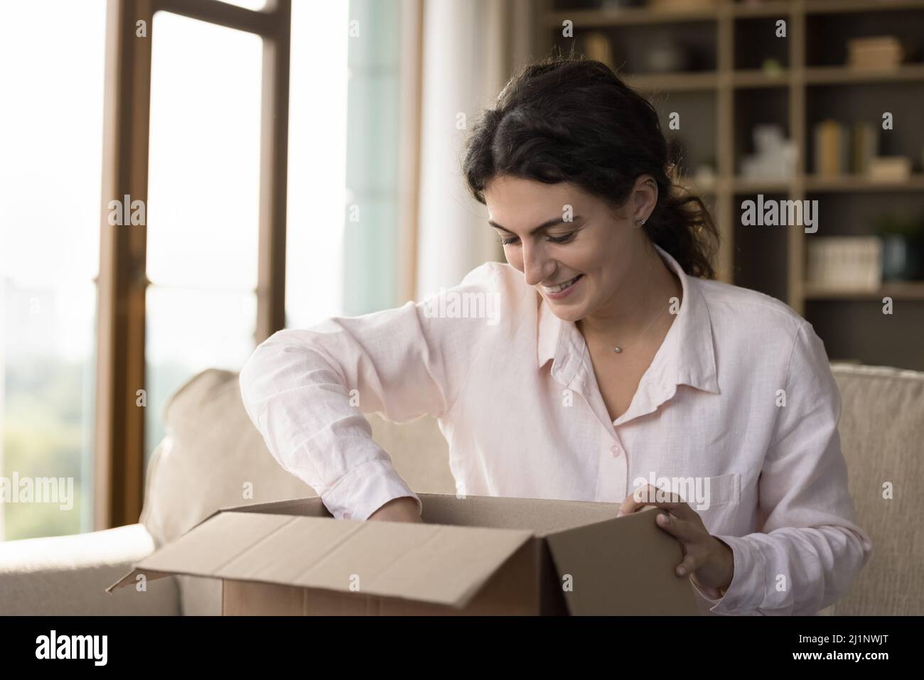 Happy satisfied customer unpacking carton box with purchase Stock Photo ...