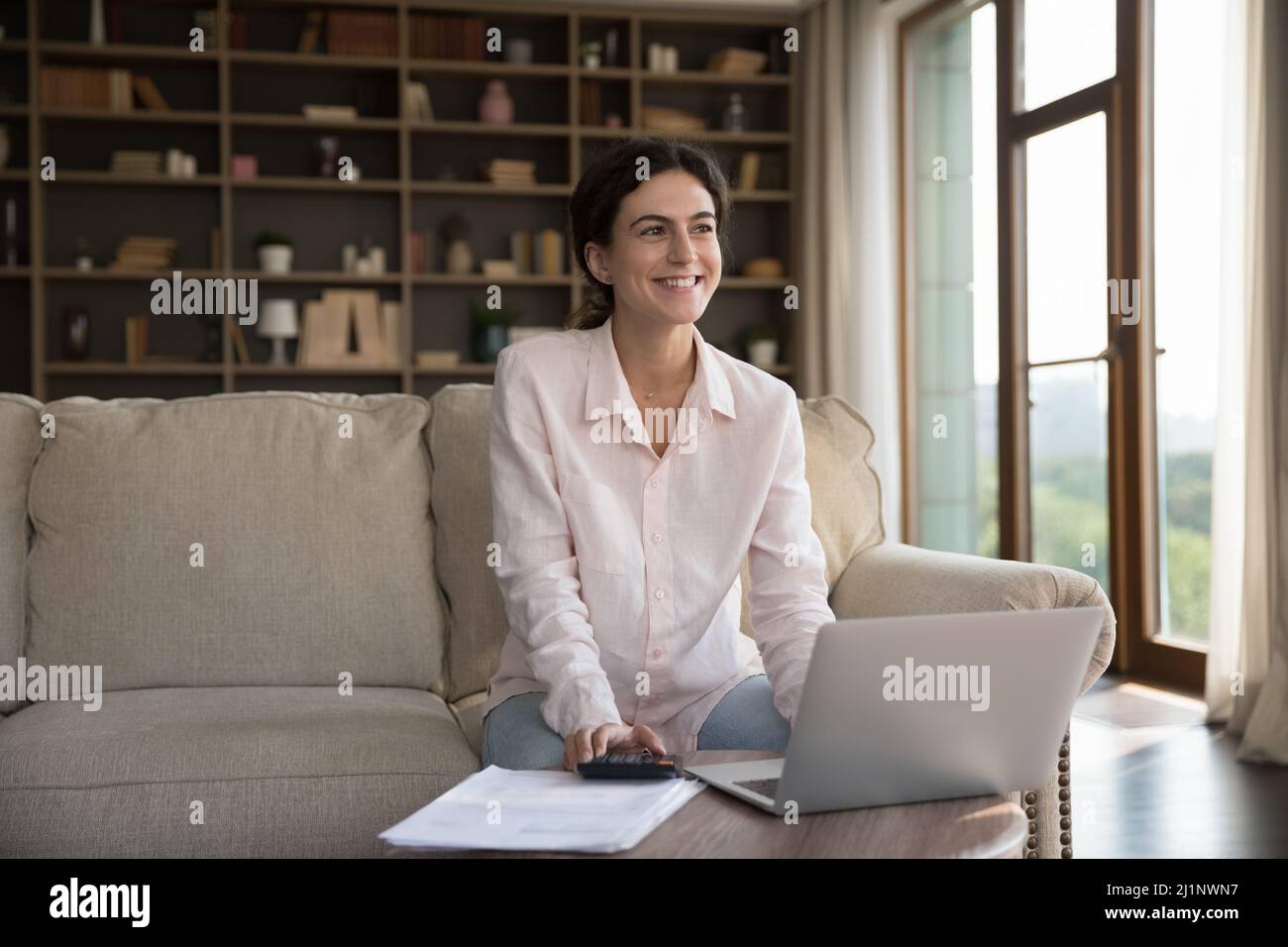 Happy thoughtful young homeowner woman doing domestic paperwork Stock ...