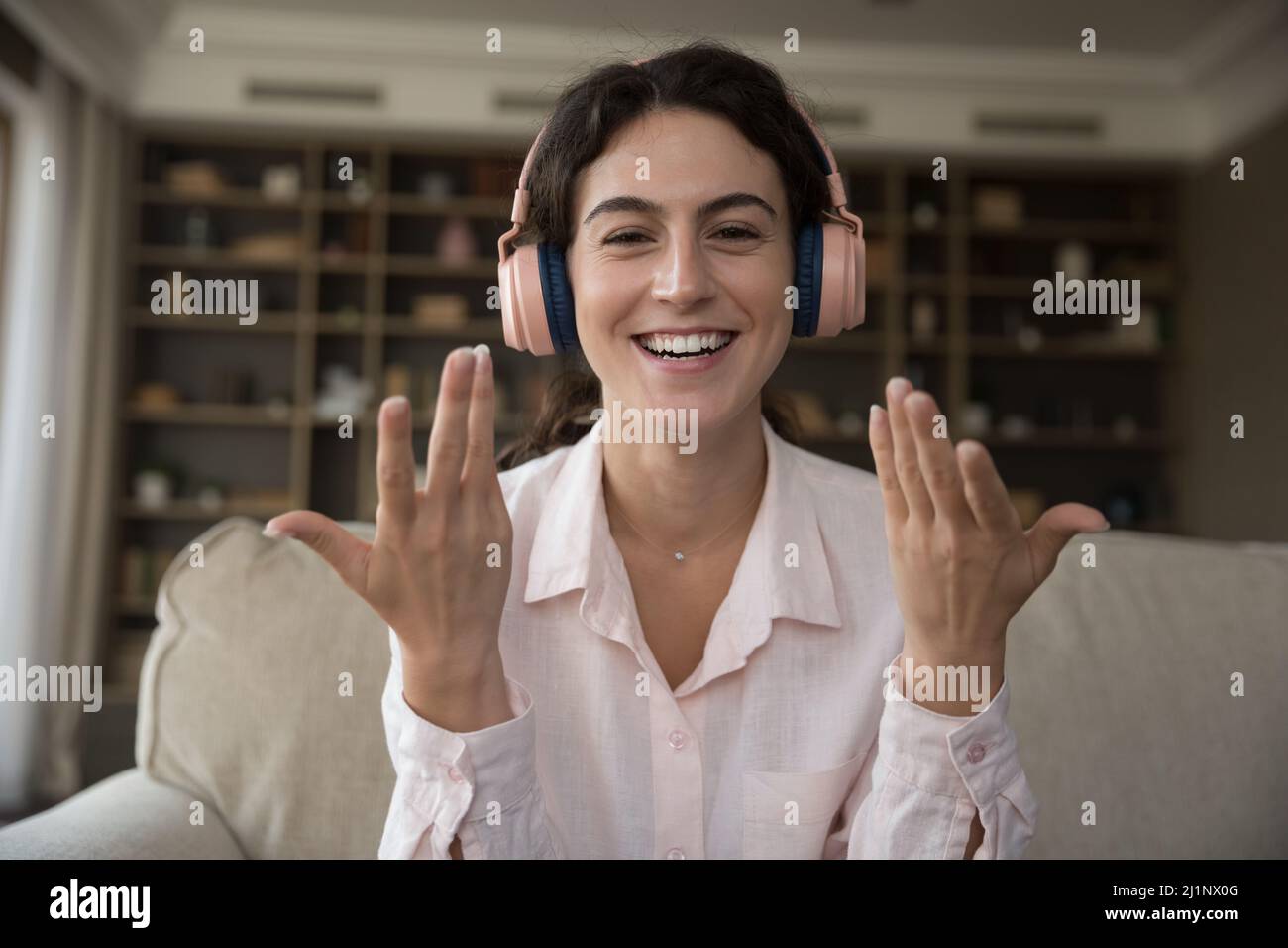 Positive student girl in pink headphones talking on video call Stock ...