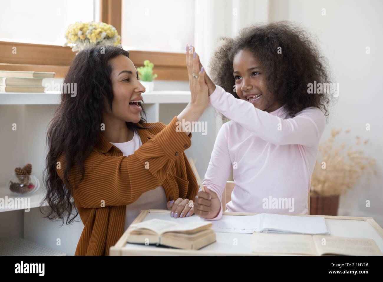 Proud mom and happy kid giving high five Stock Photo - Alamy