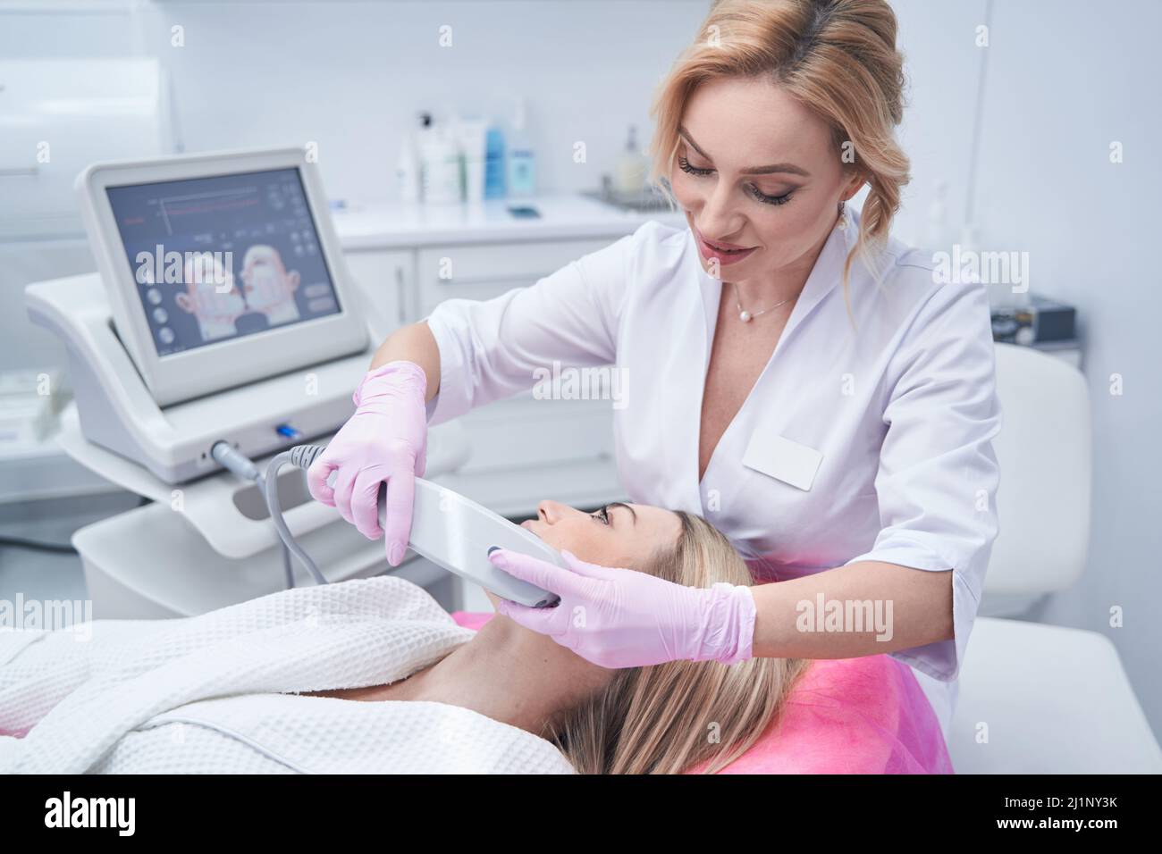 Experienced cosmetologist tightening client skin with ultrasound Stock ...