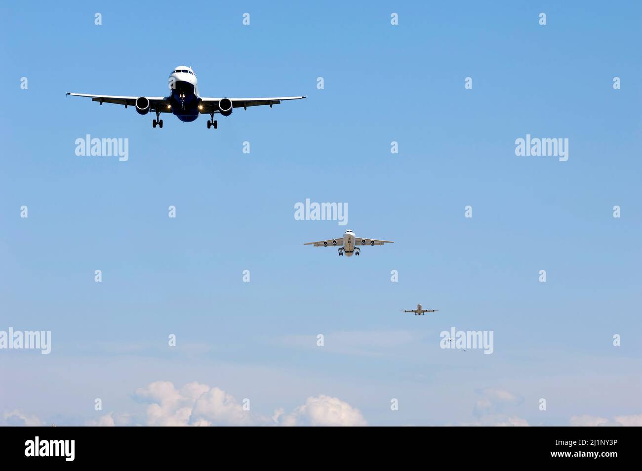 Many planes fly in a row ready to land Stock Photo - Alamy