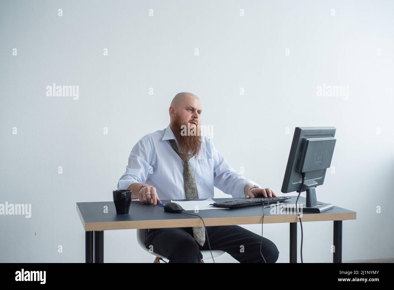 Problems for the office worker. A bald man in a white shirt sits at a ...