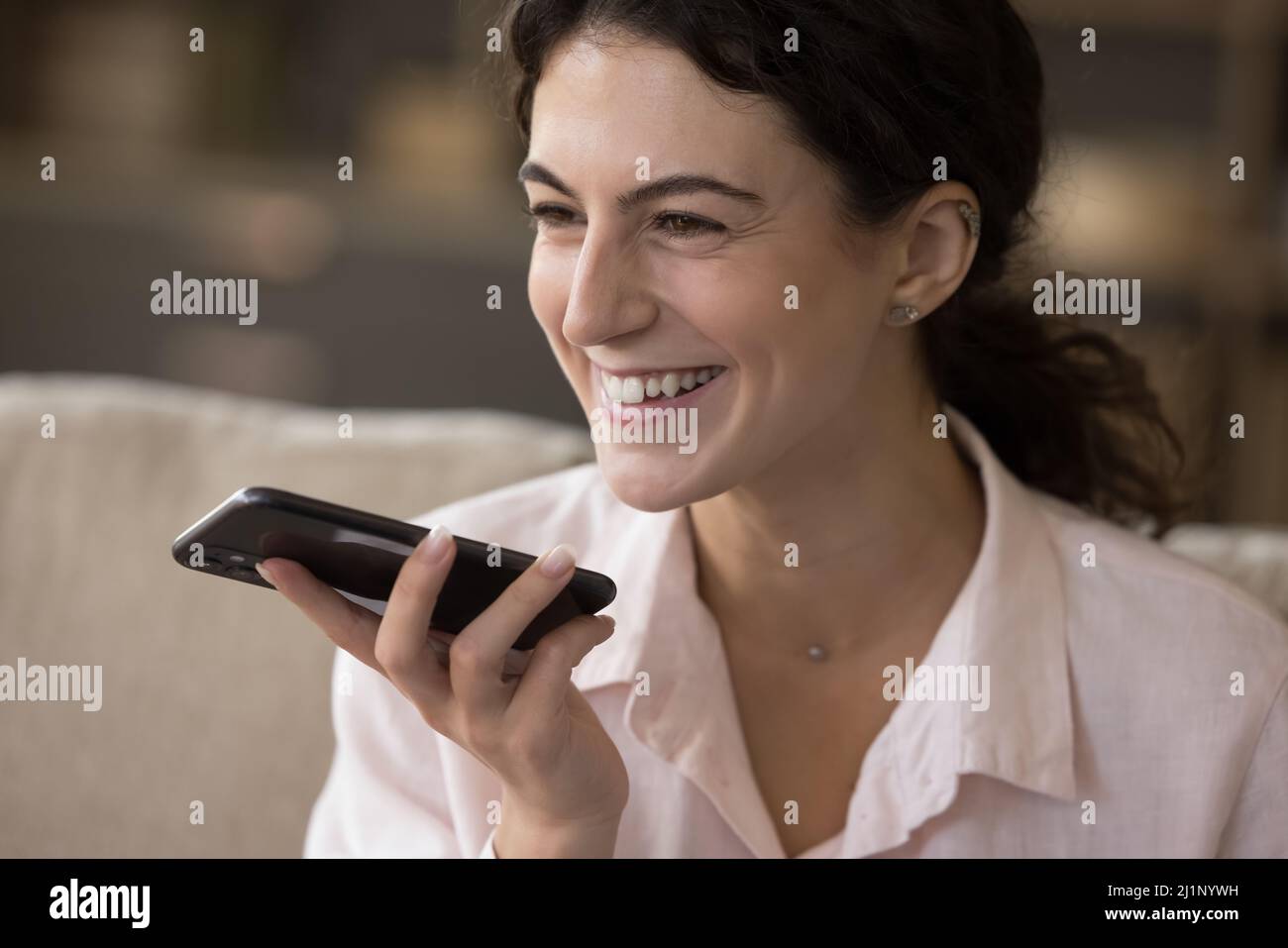 Happy joyful smartphone user woman giving commands to virtual assistant ...