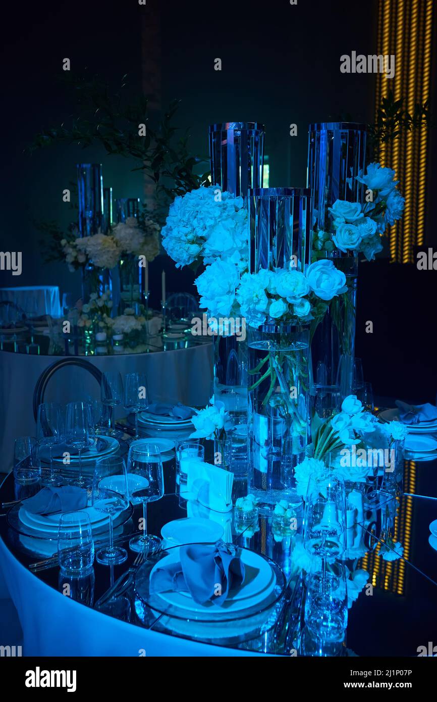 Table setup in blue light. Ready to event Stock Photo - Alamy