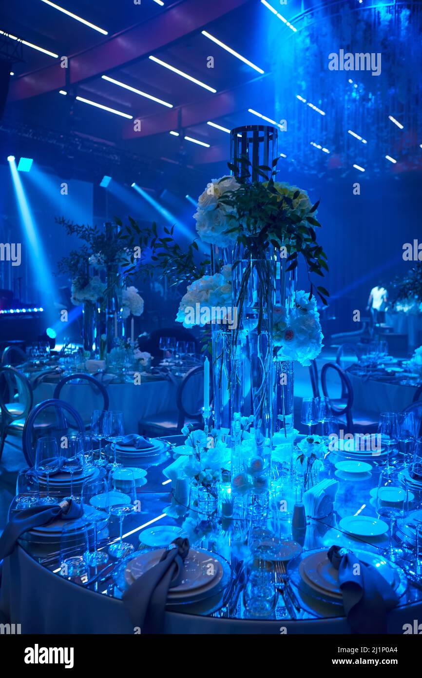 Table setup in blue light. Ready to event Stock Photo - Alamy