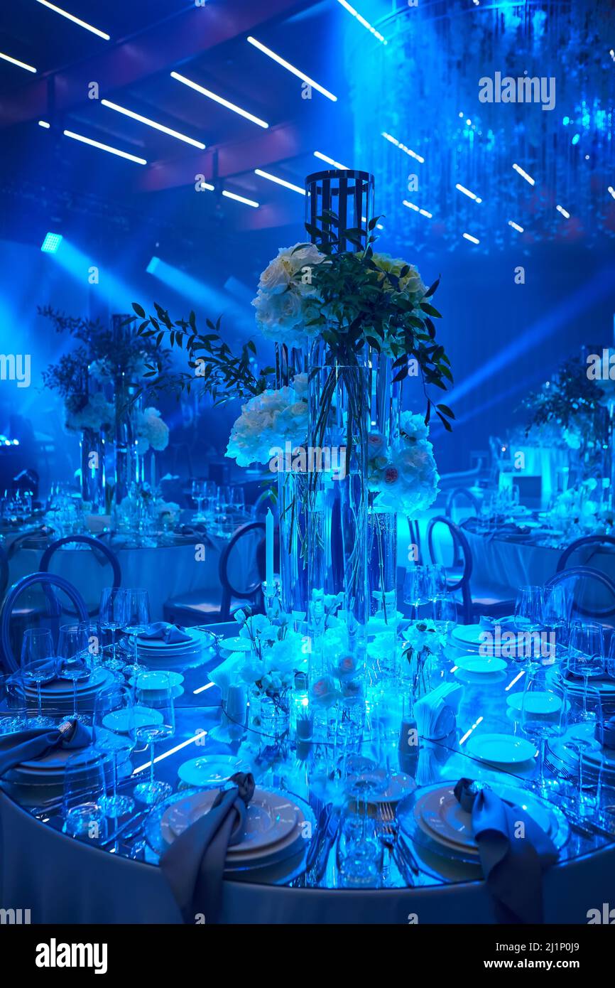Table setup in blue light. Ready to event Stock Photo - Alamy