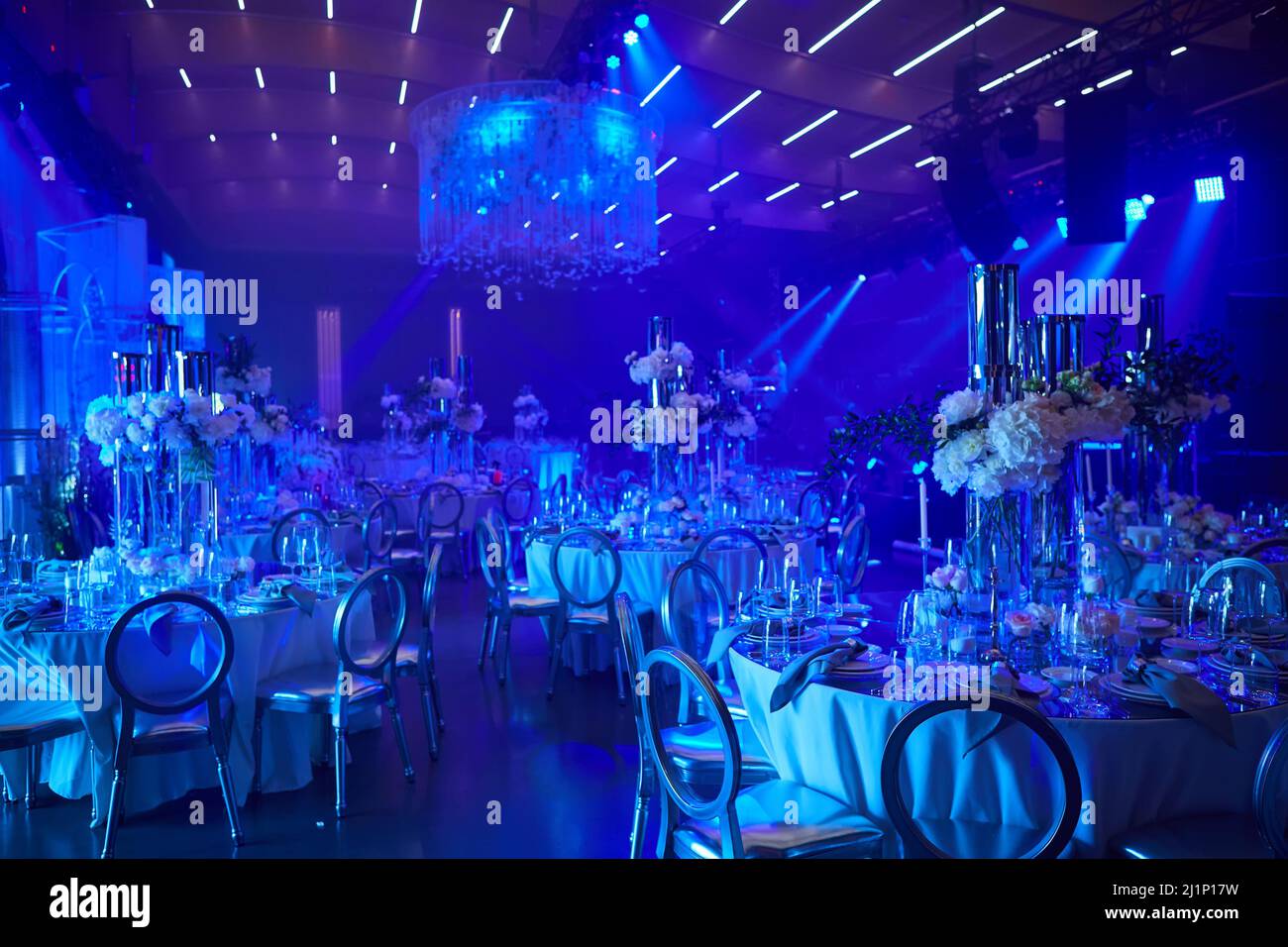 Table setup in blue light. Ready to event Stock Photo - Alamy