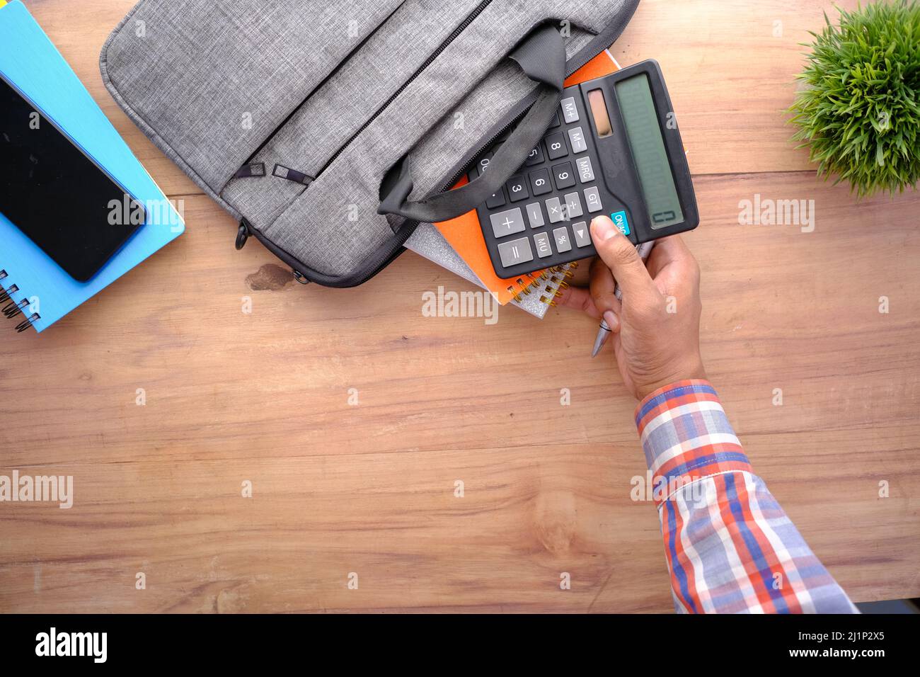 top view of young man putting office stationary in his bag Stock Photo ...