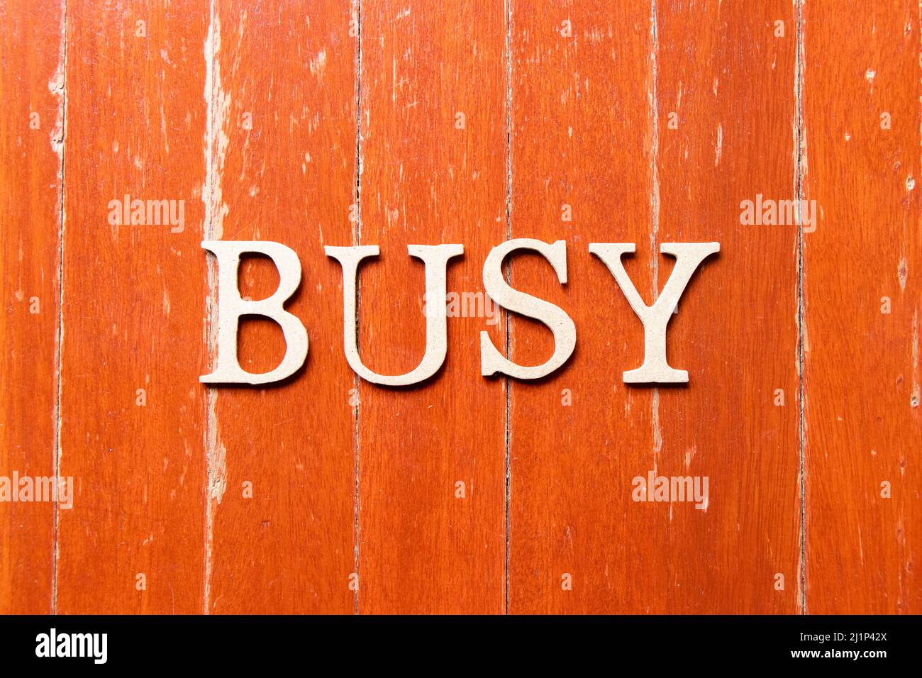 Alphabet letter in word busy on old red color wood plate background ...
