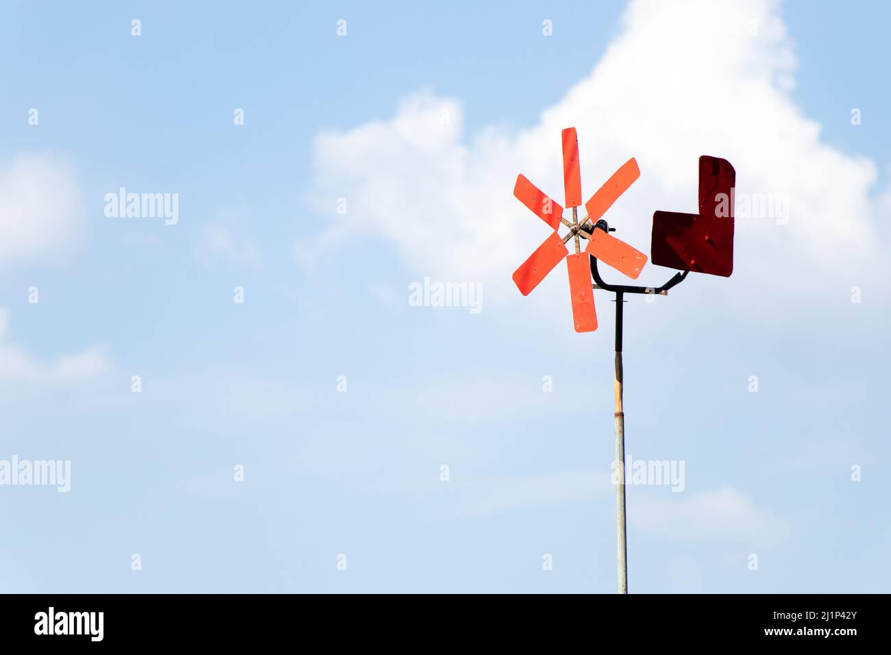Red color windmill on blue sky background Stock Photo - Alamy