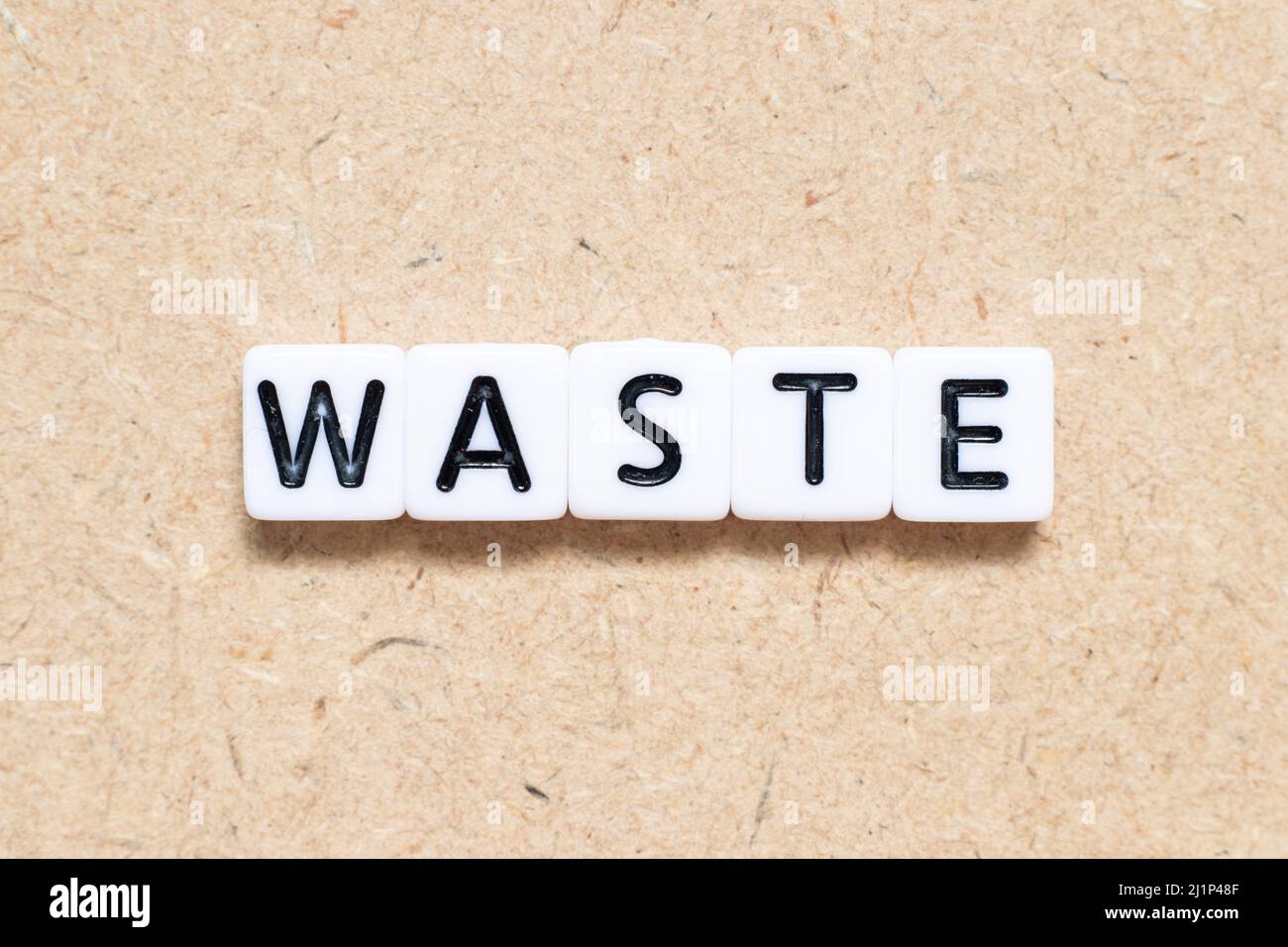 White tile alphabet letter with word waste on wood background Stock ...