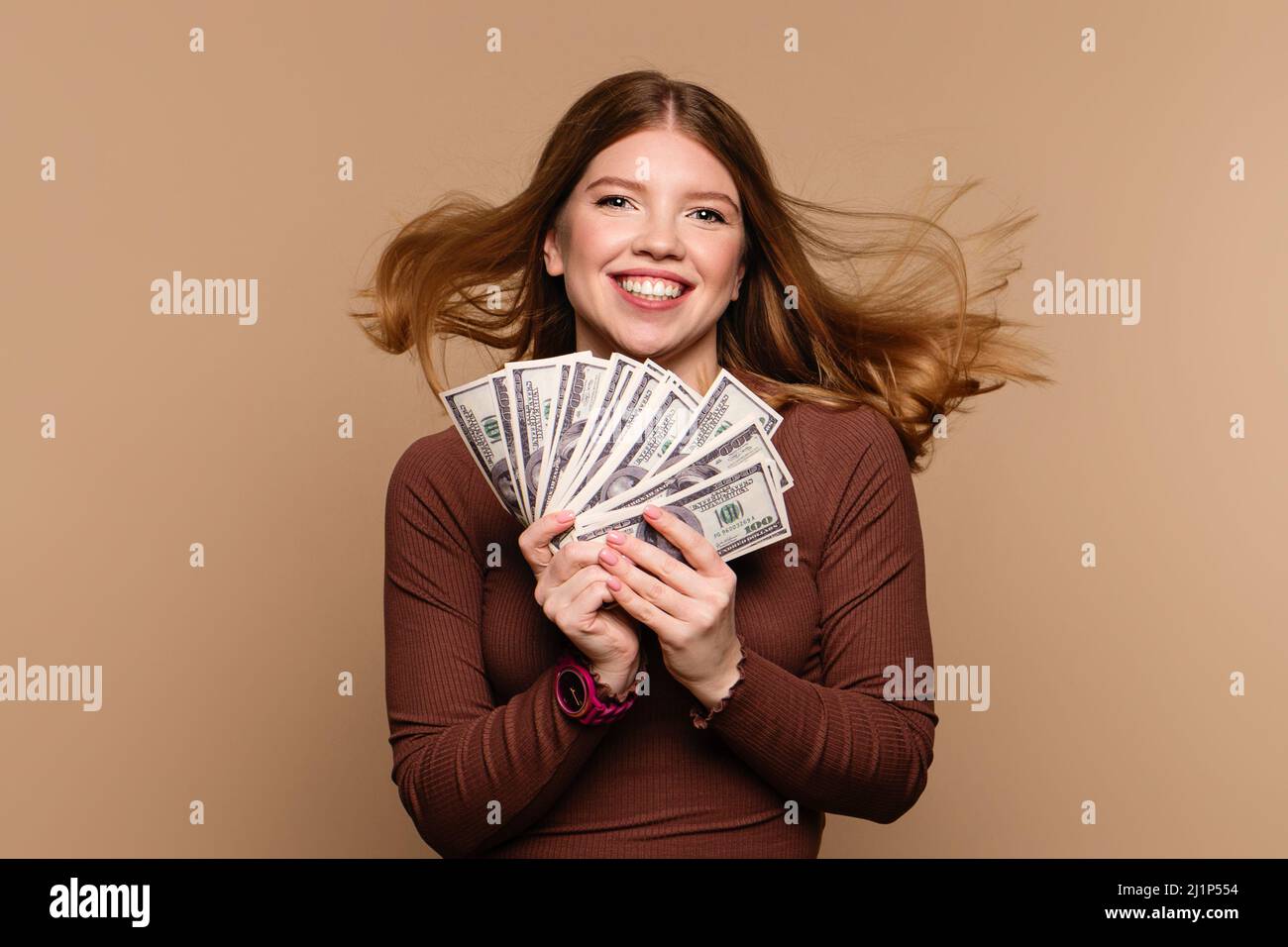 Wide smiling cute woman with dollar fan and flowing hair. Healthy hair ...
