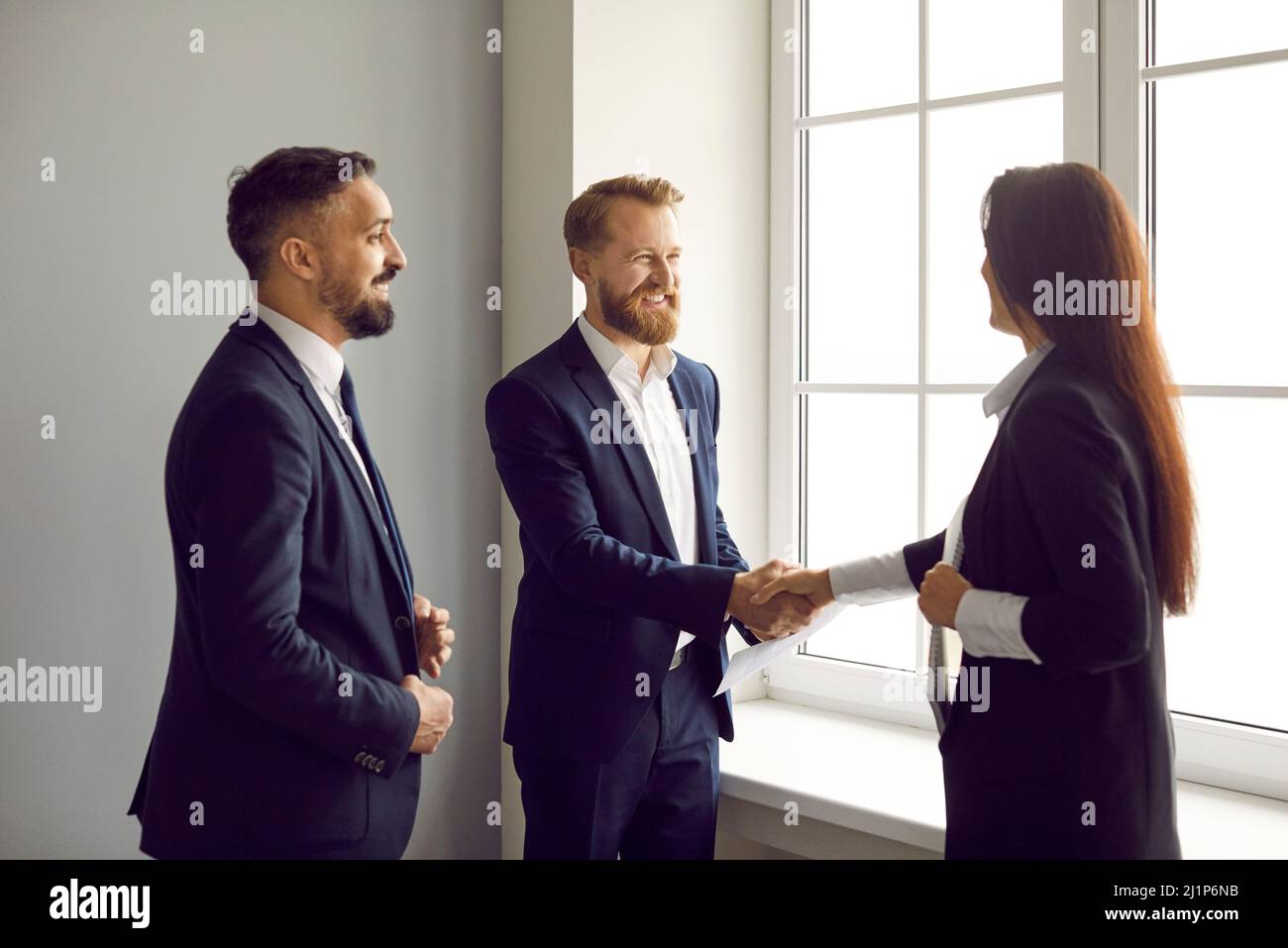 Happy business people shake hands in agreement and end successful ...