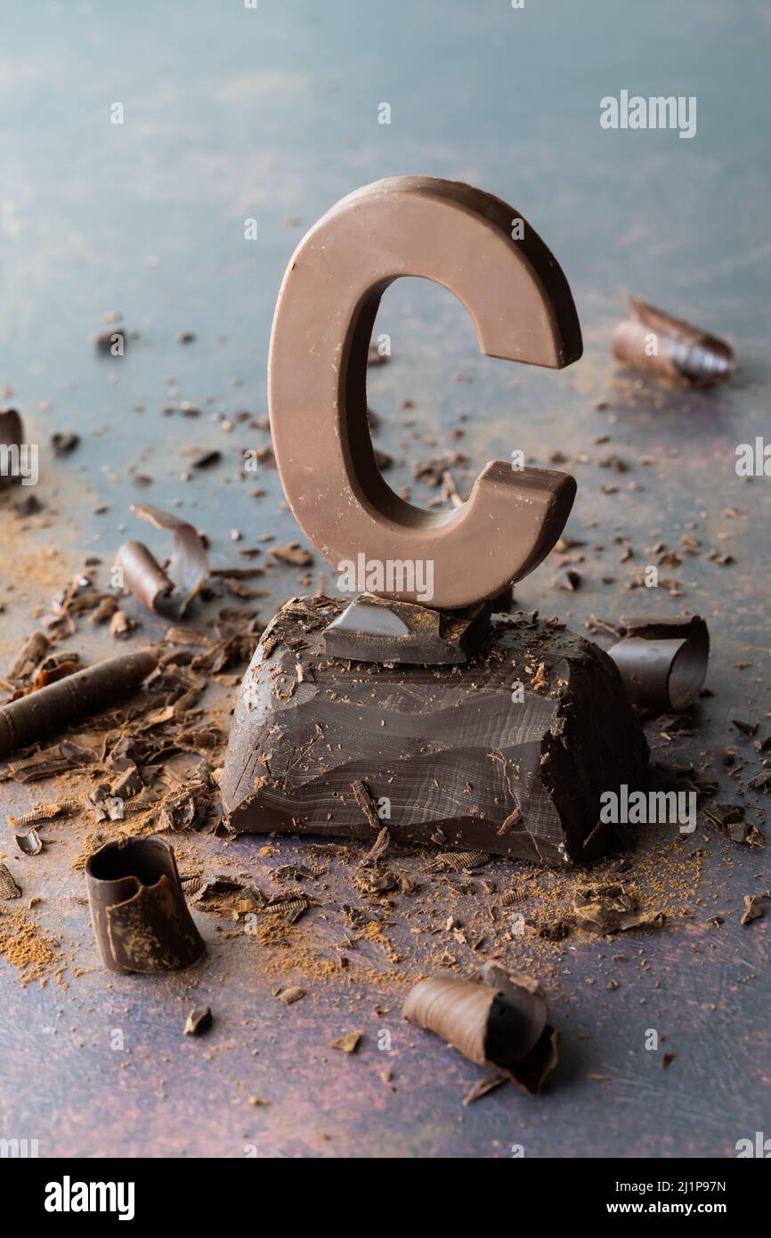 A chocolate letter C on a chocolate block with chocolate shavings and ...