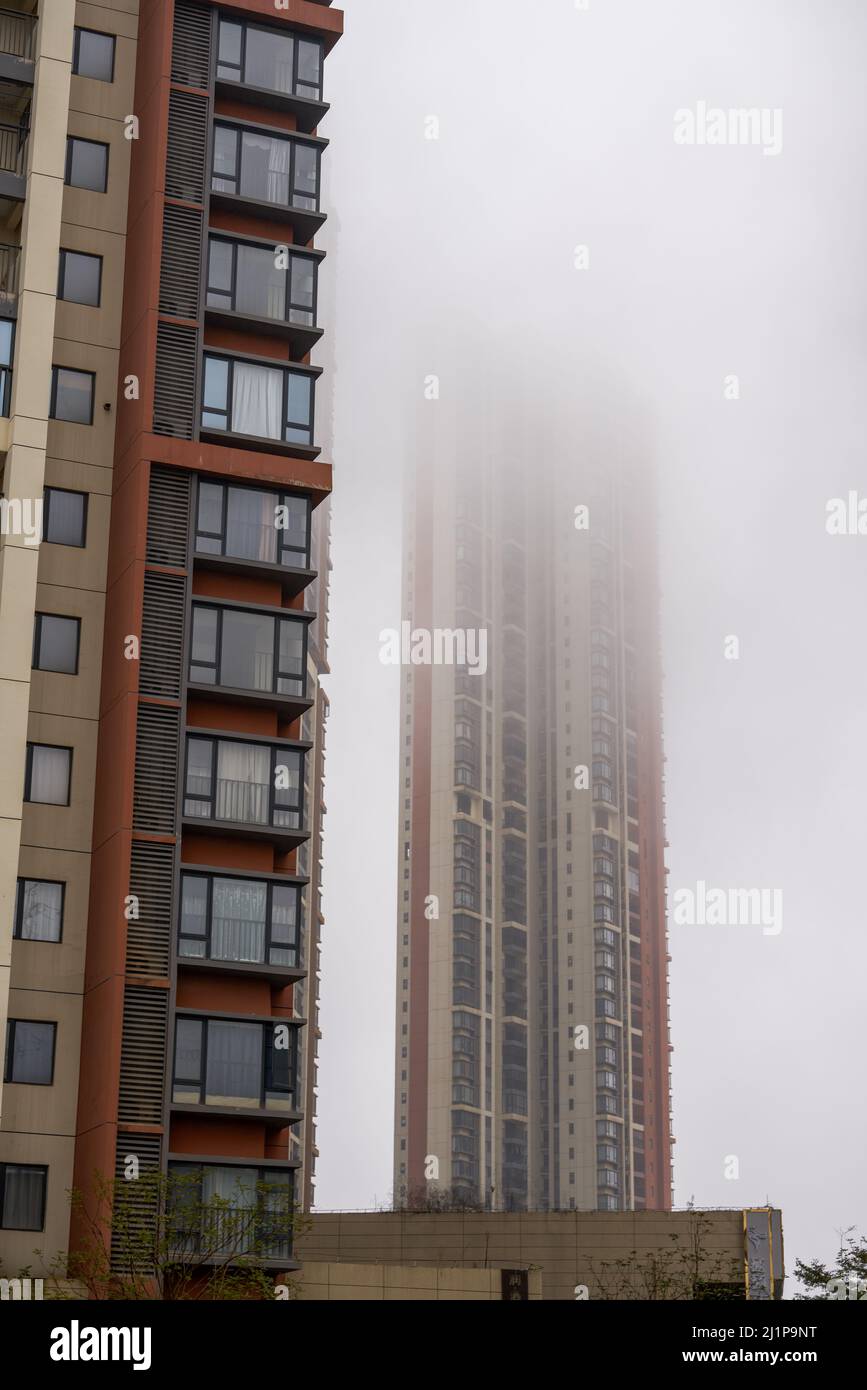 Urban residential high-rise buildings in dense fog in rainy weather ...