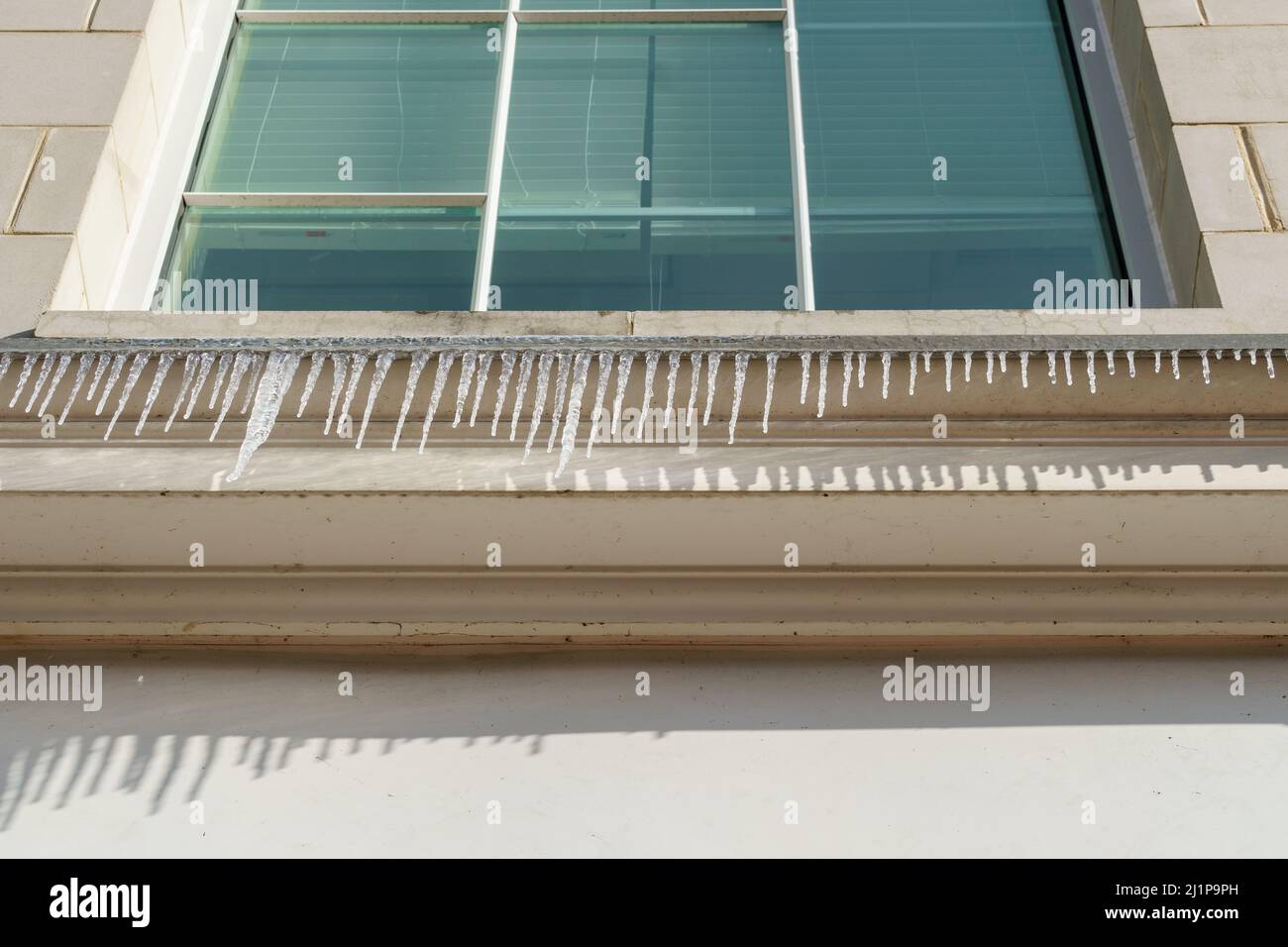 Sunny window ledge with icicles and shadows underneath Stock Photo - Alamy