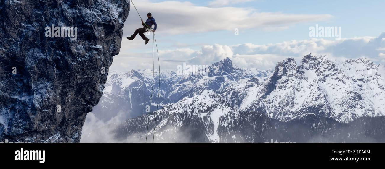Adult adventurous man rappelling down a rocky cliff Stock Photo - Alamy