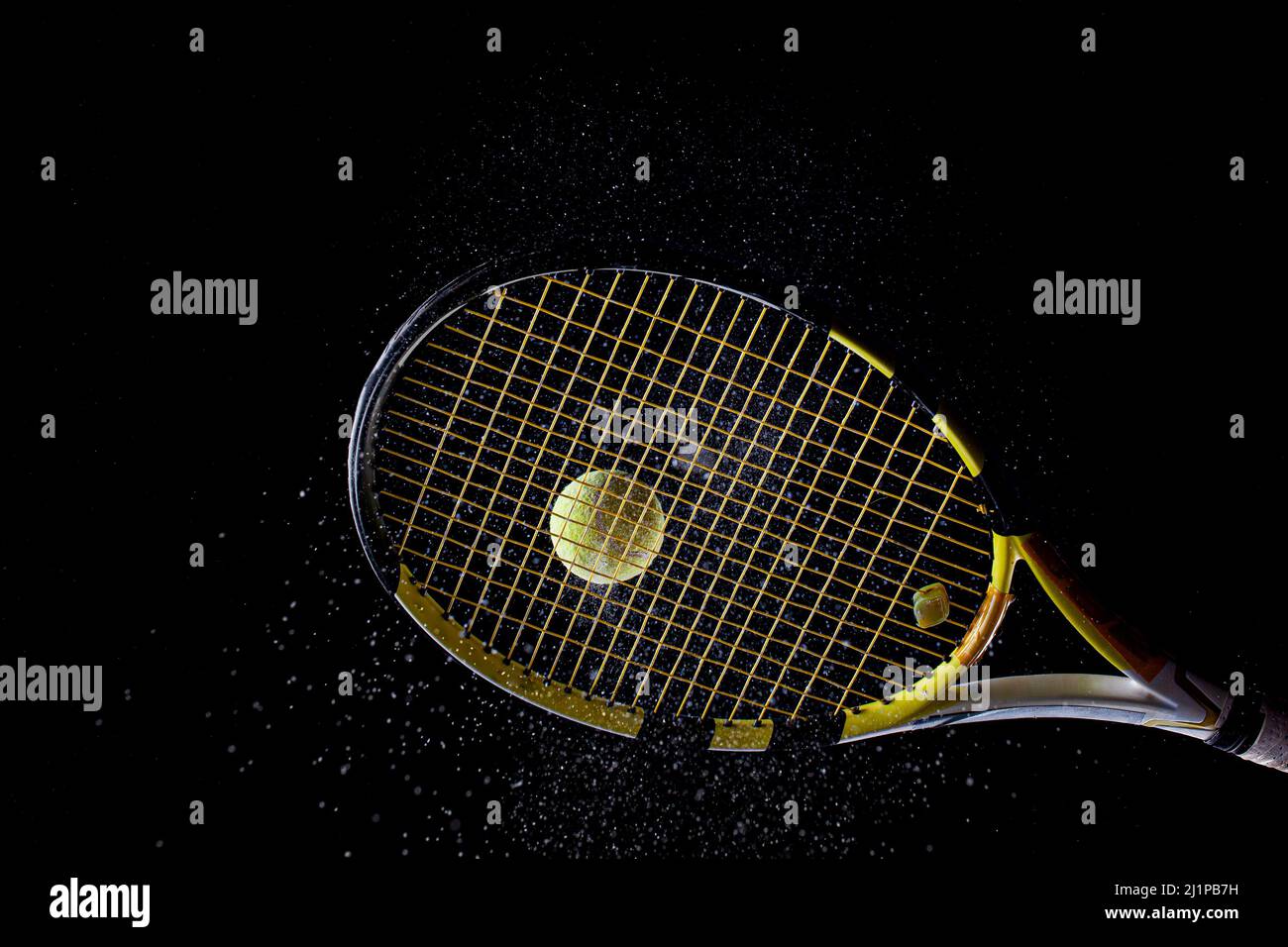 Tennis ball bouncing on racket. Dirt or magnesium dust dots visible in ...