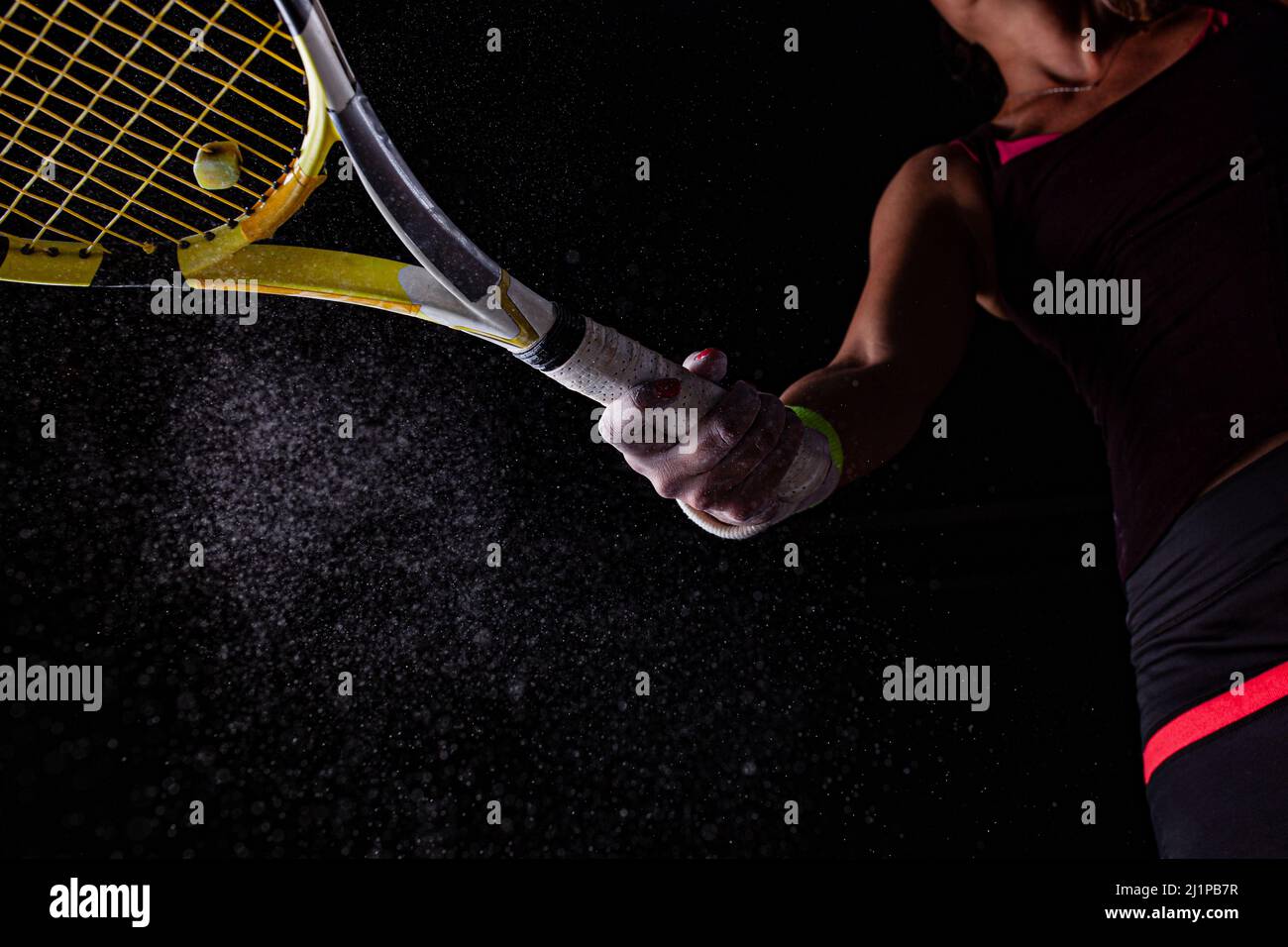 Tennis ball bouncing on racket. Dirt or magnesium dust dots visible in ...