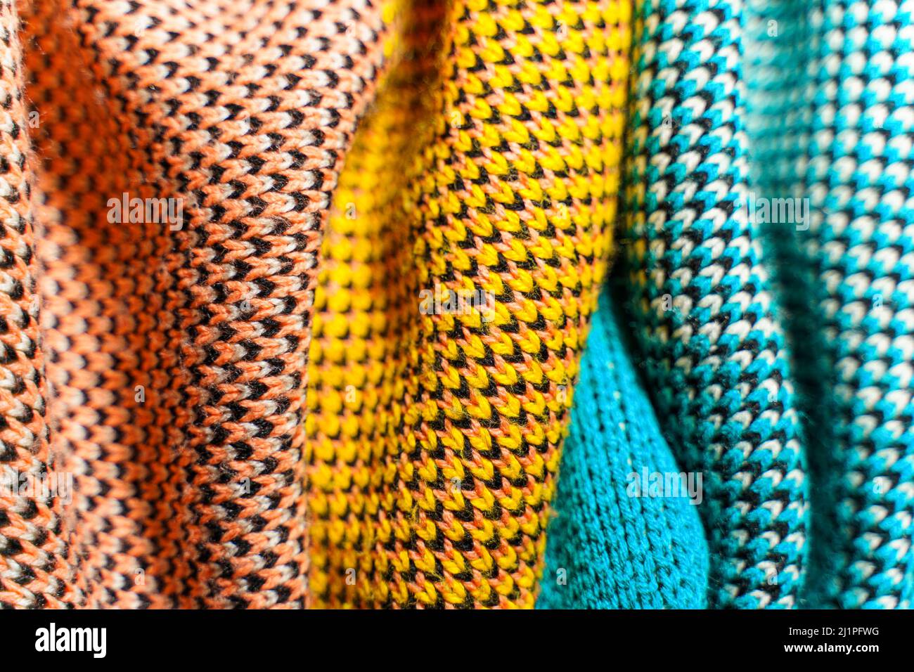 A pile of multi-colored synthetic knitted fabrics of different ...