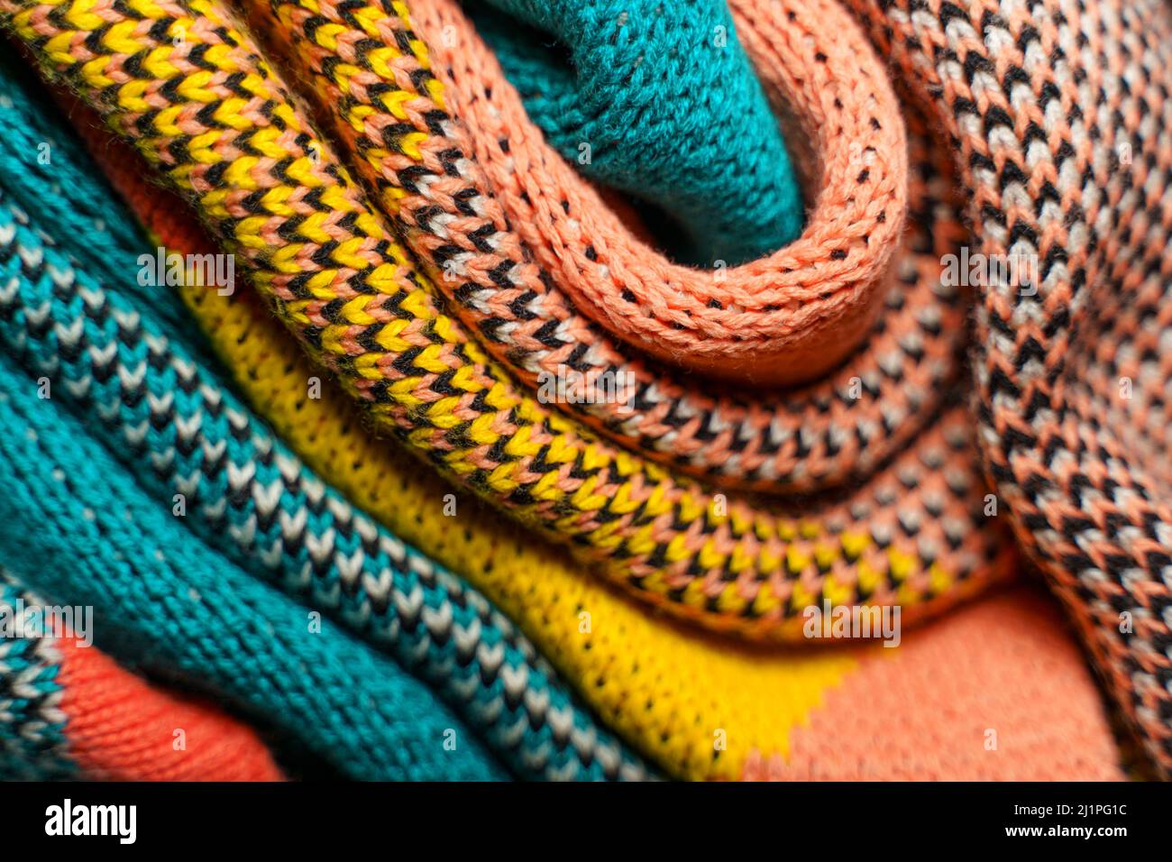 Twisted folds of colorful knitted fabrics of winter clothes with ...