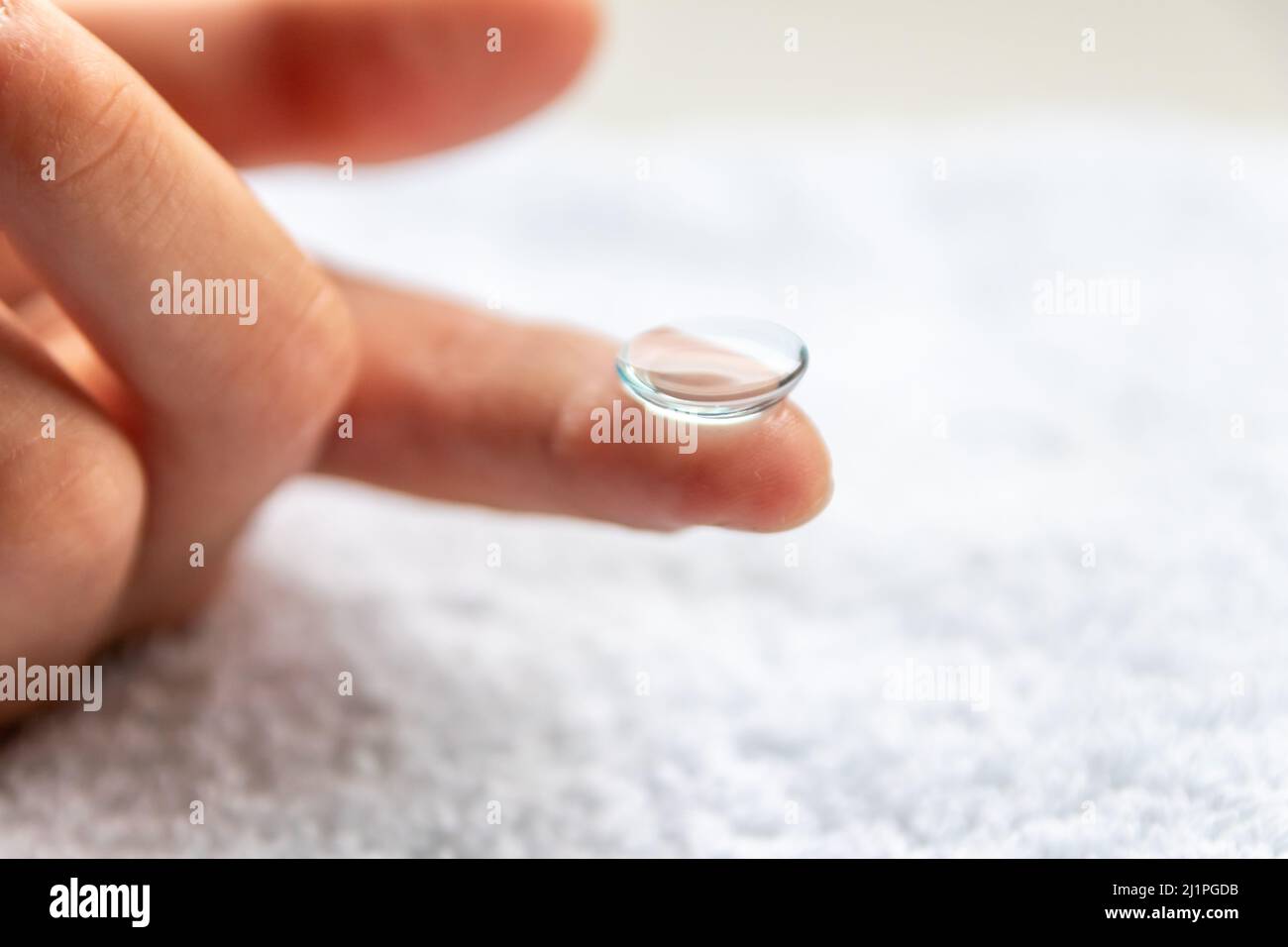Contact lense cleaning on finger to correct nearsightedness and blurred ...