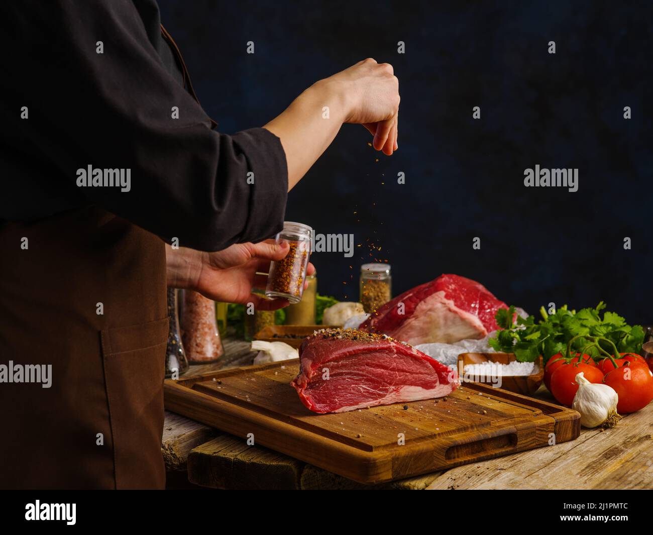 Cooking meat by the hands of a professional chef on a wooden cutting ...